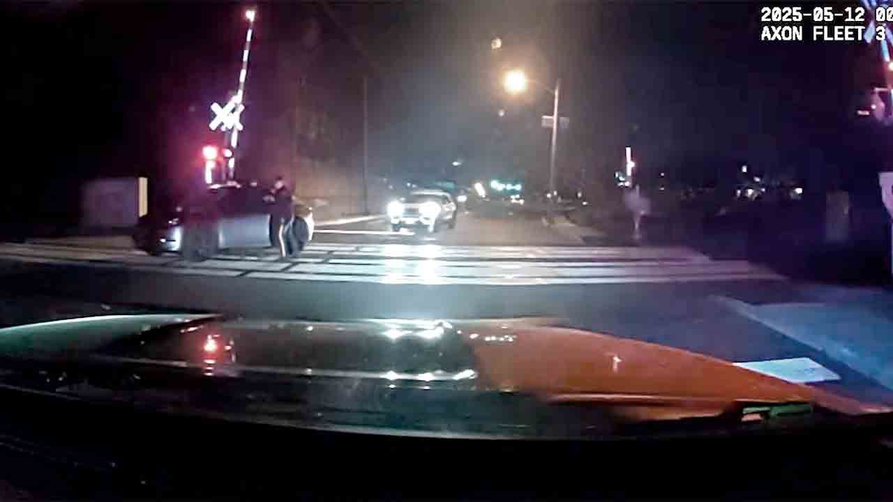 Police officers save man from car stuck on train tracks seconds before ...